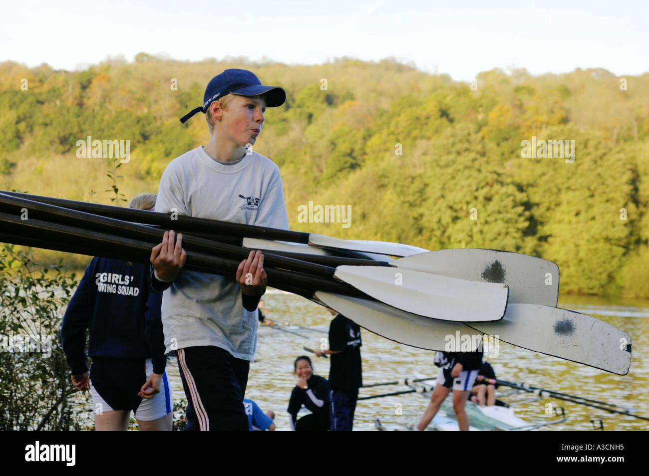 boy assisting at junior rowing event by carrying blades at event on ...