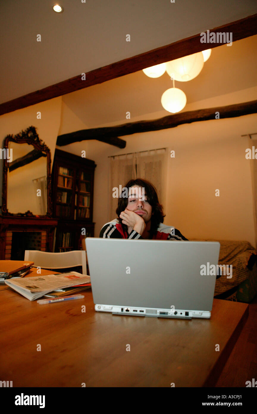 Young man looking bored in front of laptop computer Stock Photo - Alamy