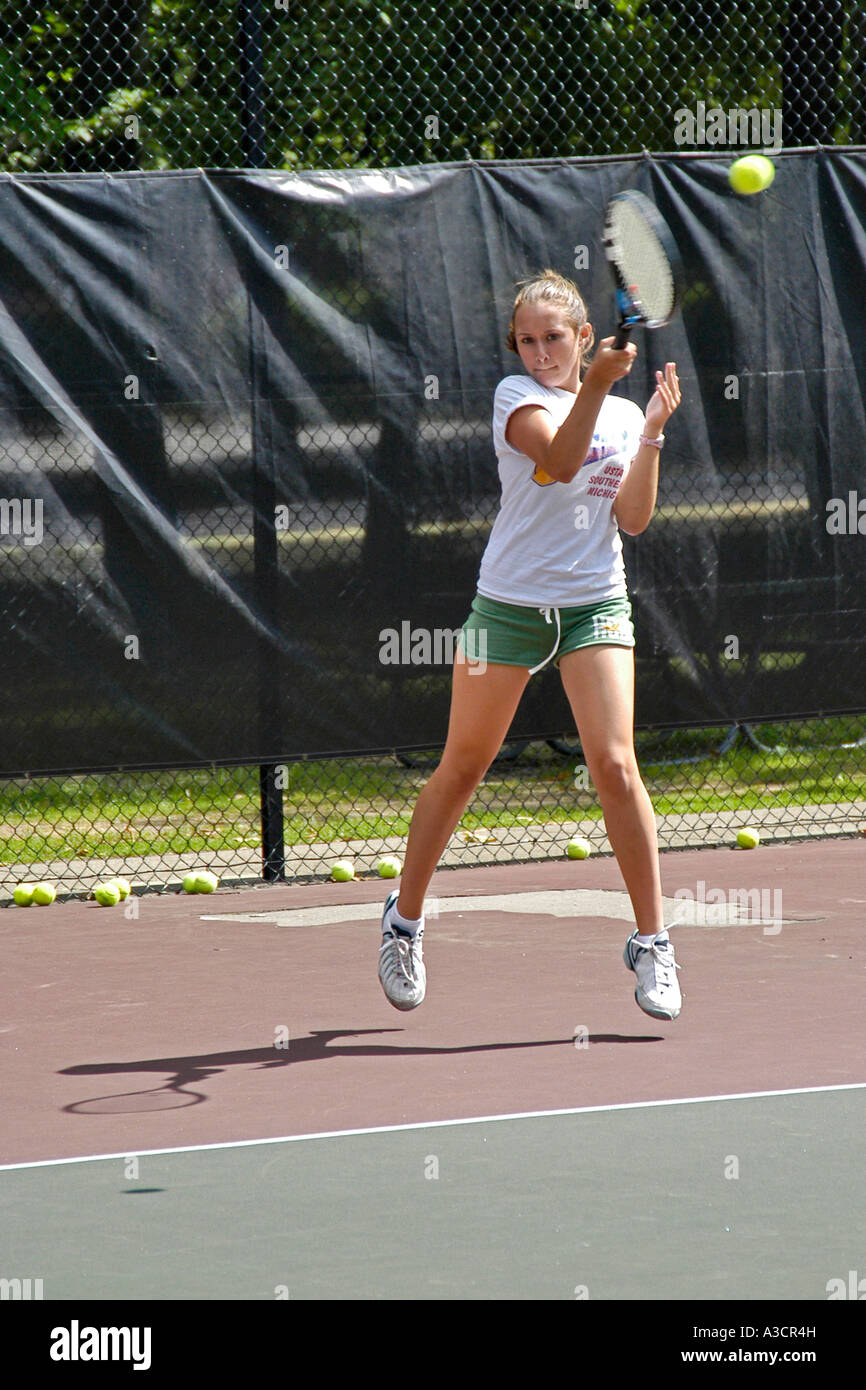 Teenage female taking Tennis lessons in a public summer-school program ...