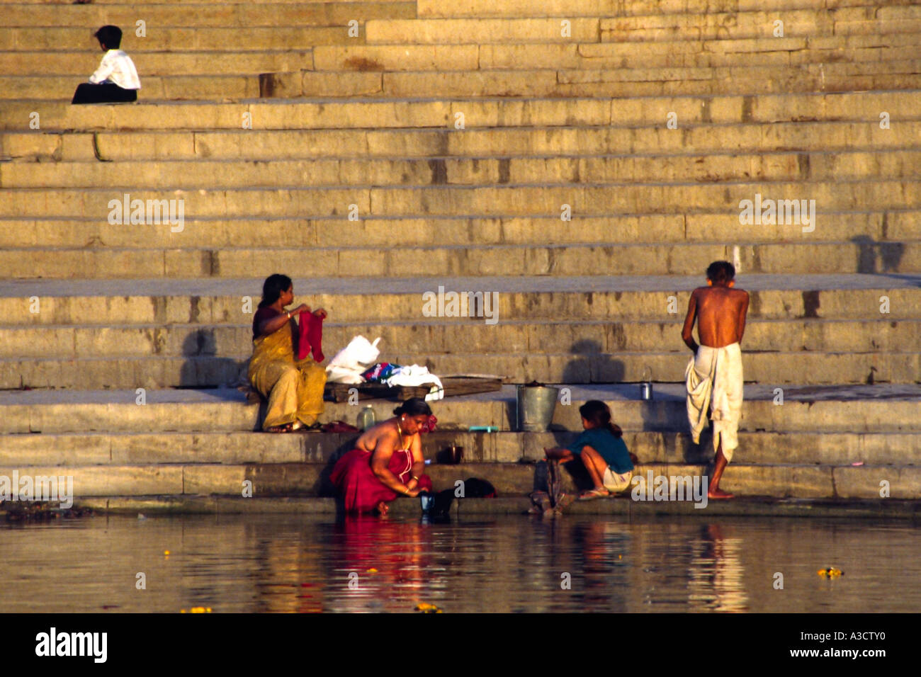Worshippers washing clothes on the ghats beside the river ganges in ...