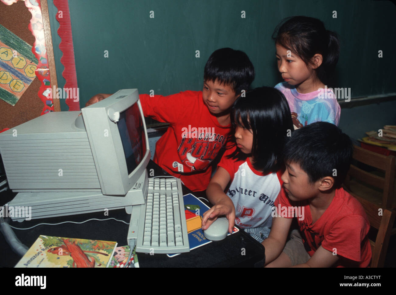 Children work together at a computer at an elementary school in the ...