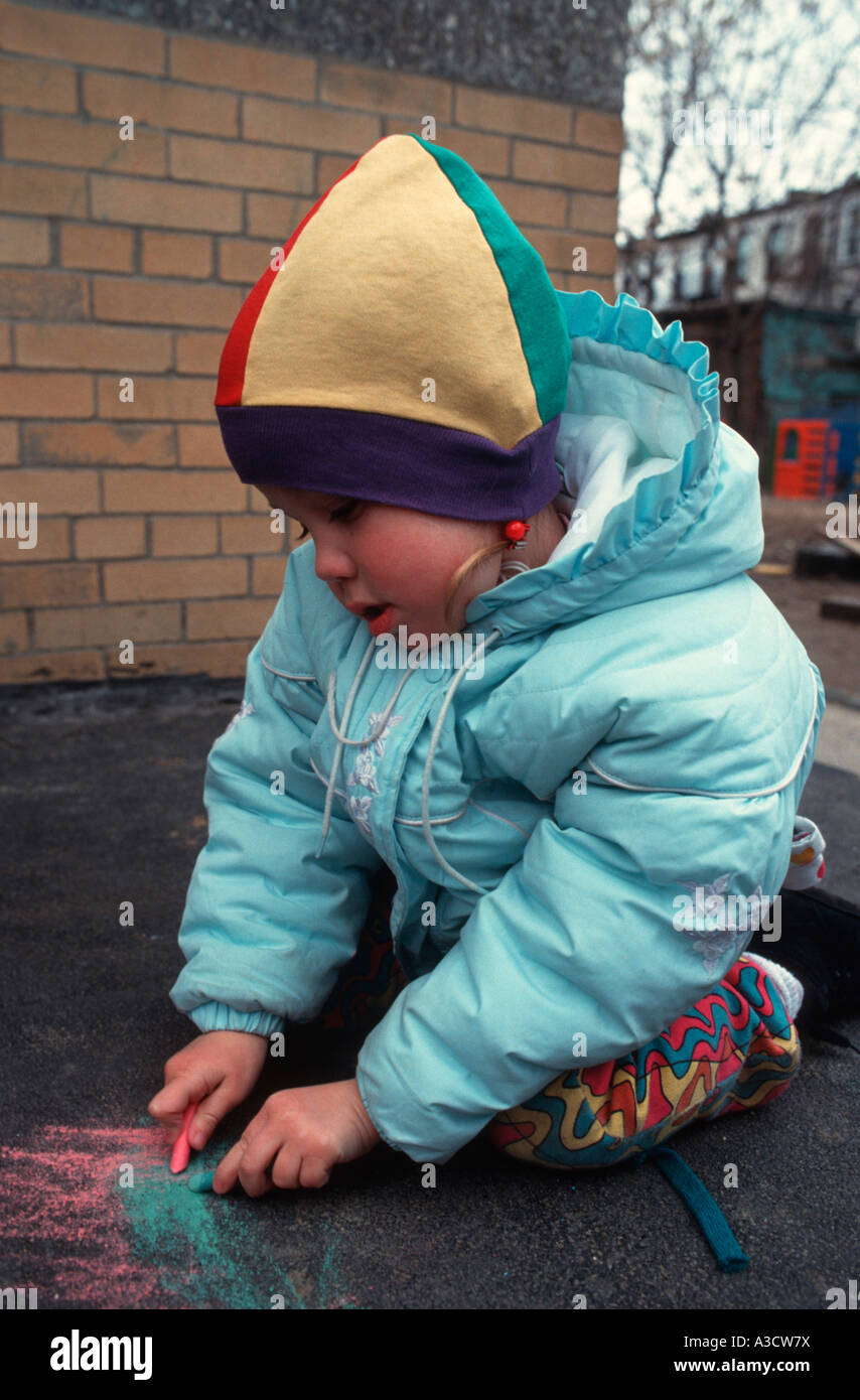 Nursery school child draw with chalk on the playground in Brooklyn New ...