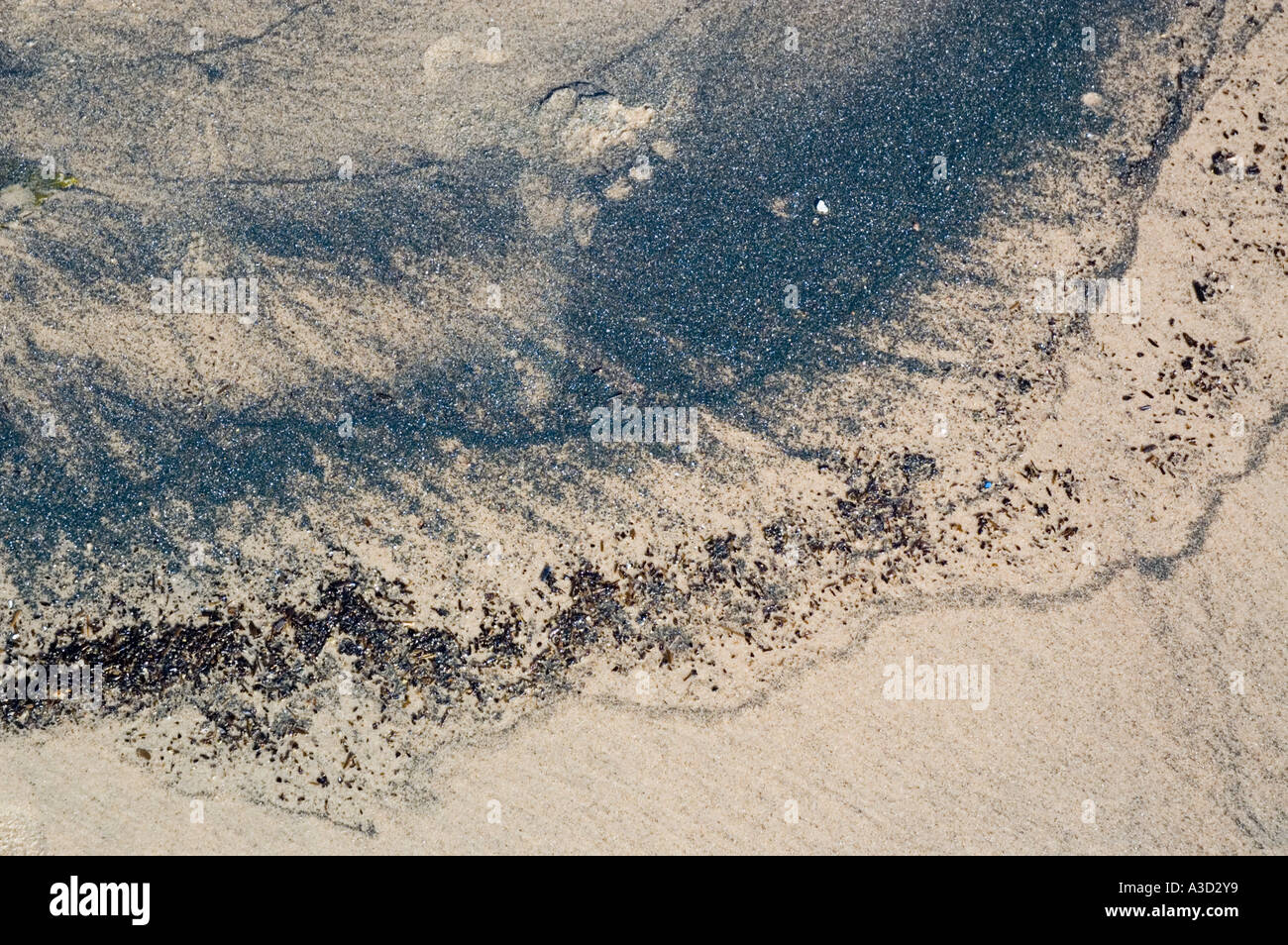 Black pattern formed on beach by water waves Stock Photo - Alamy