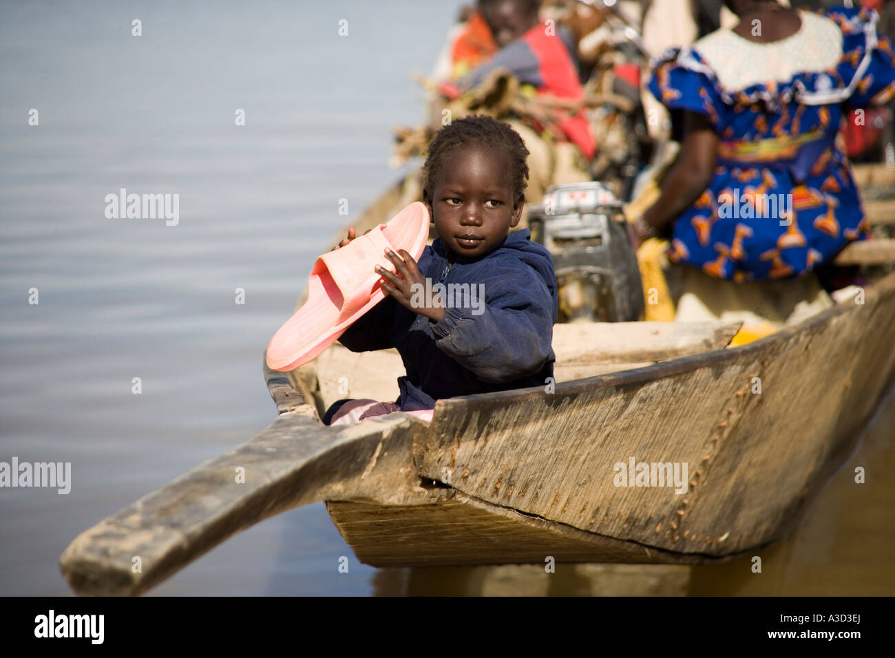 Small boy on a passenger Pirogue on the Bani river ferrying people to ...