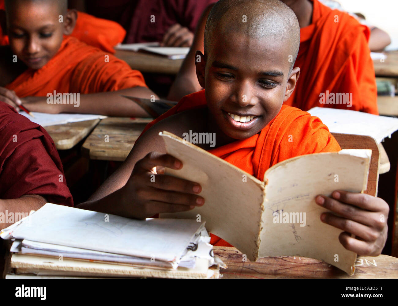 close up portrait of young student Buddhist monk in school at his desk ...
