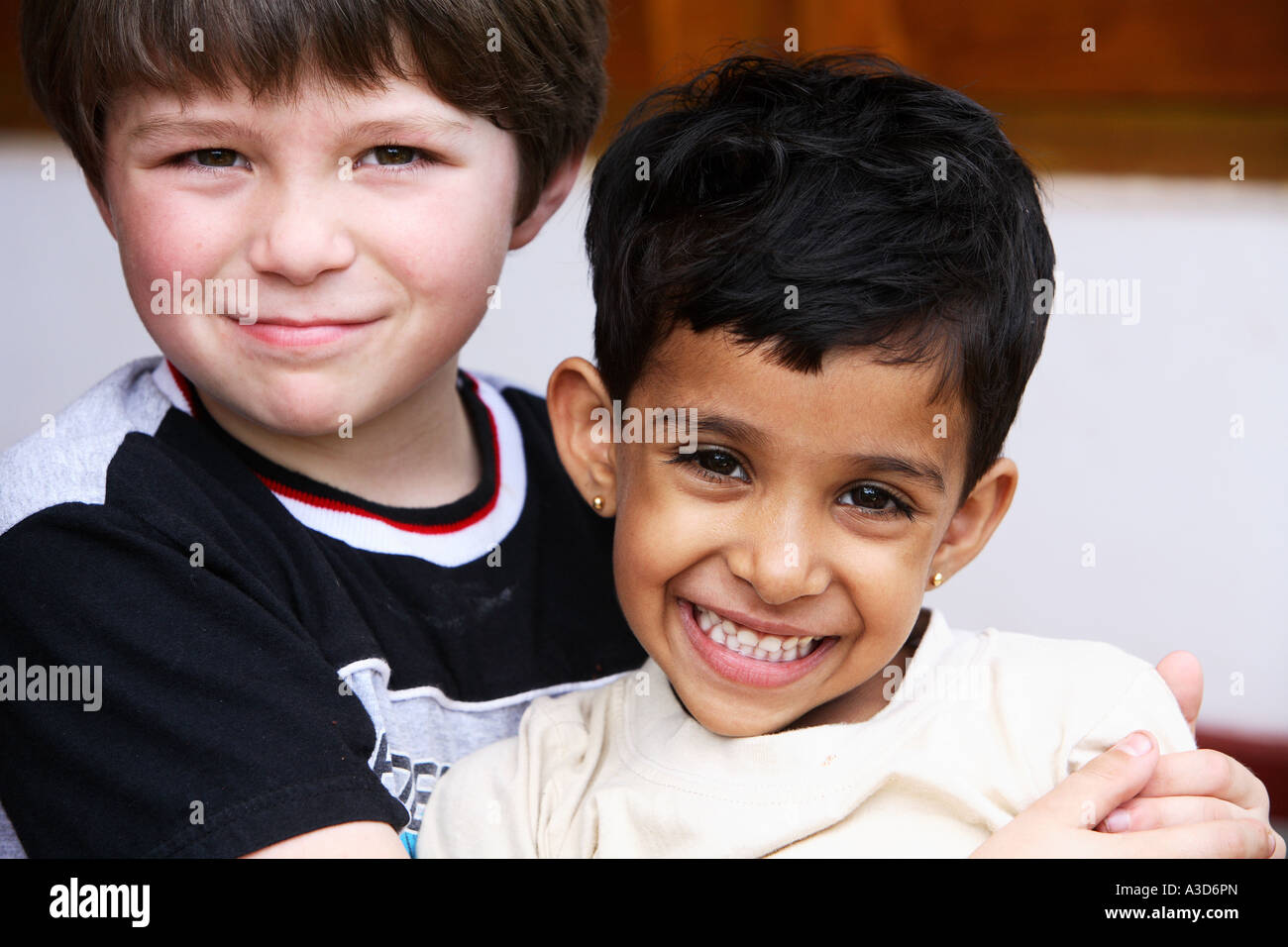 Two children of different race hug and smile, overcoming their language ...