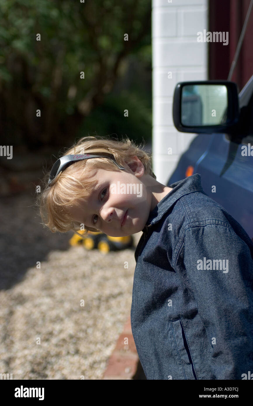 Little boy leaning against car in sunshine Stock Photo - Alamy