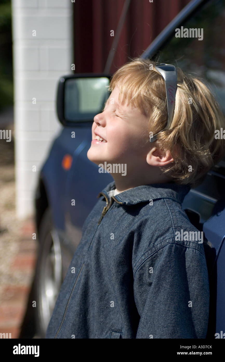 Little boy leaning against car in sunshine Stock Photo - Alamy