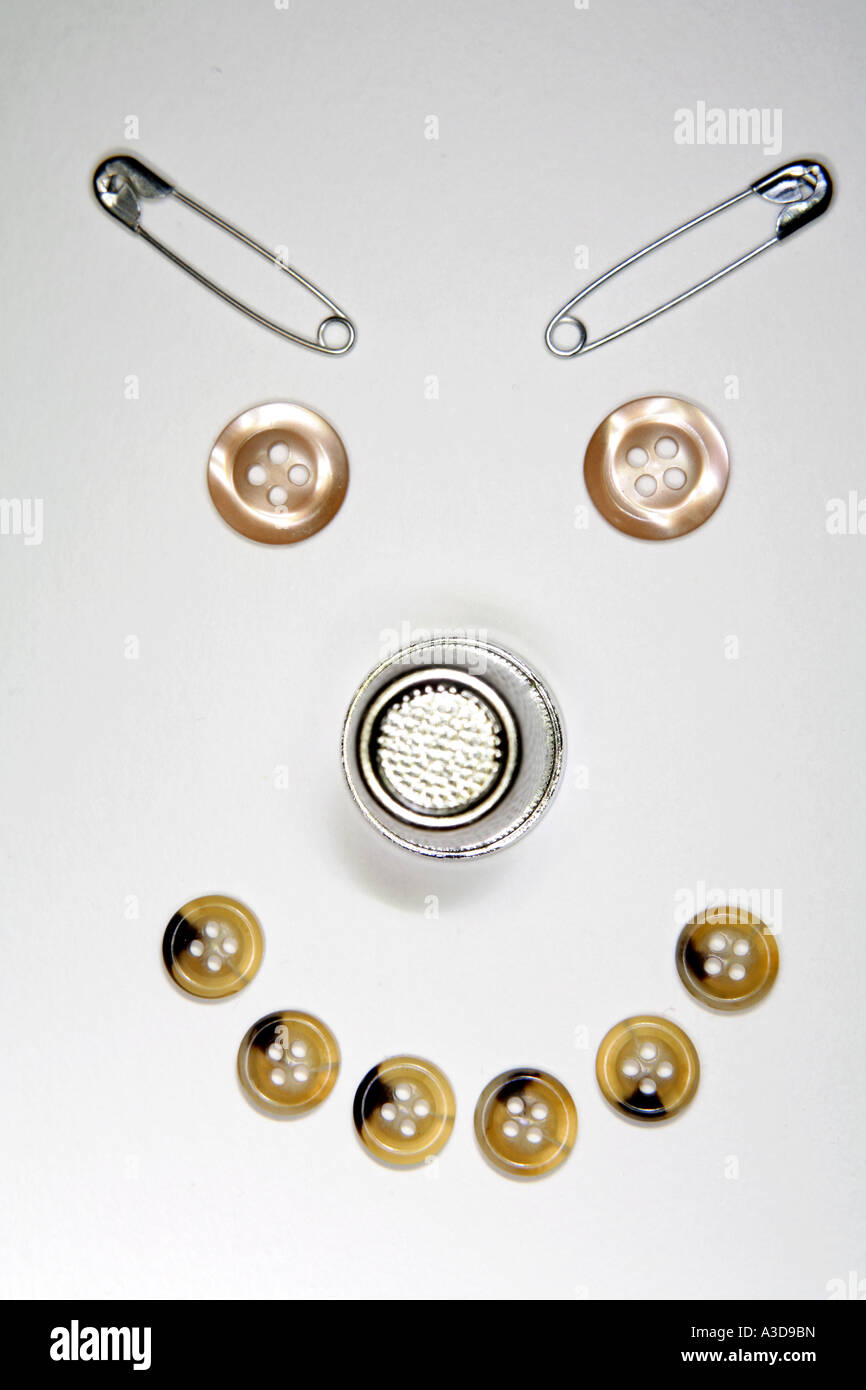 Face made from buttons, safety pins and thimble Stock Photo - Alamy