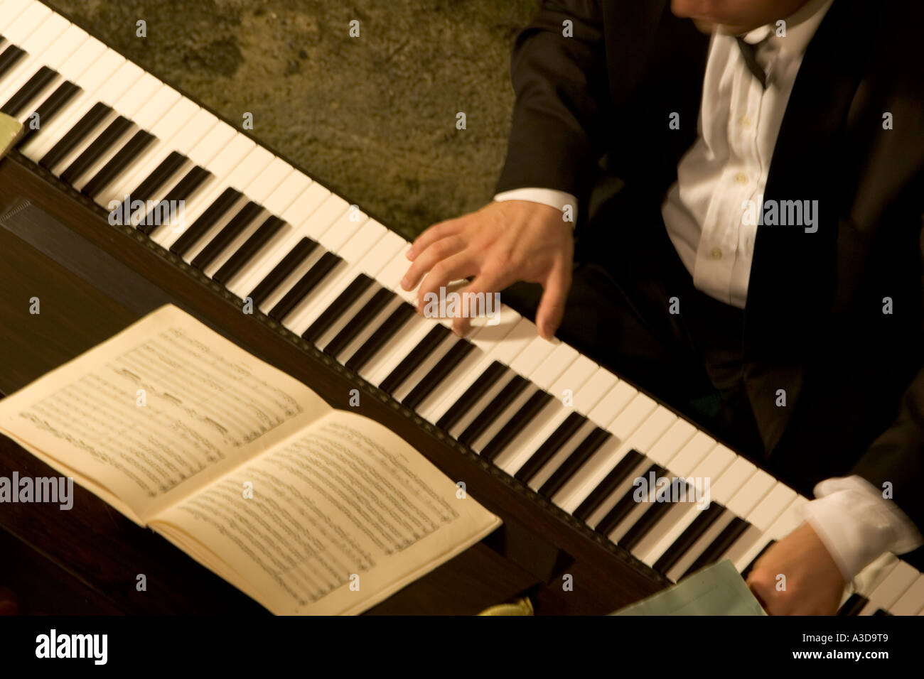 Pianist playing piano keyboard in formal attire Stock Photo - Alamy