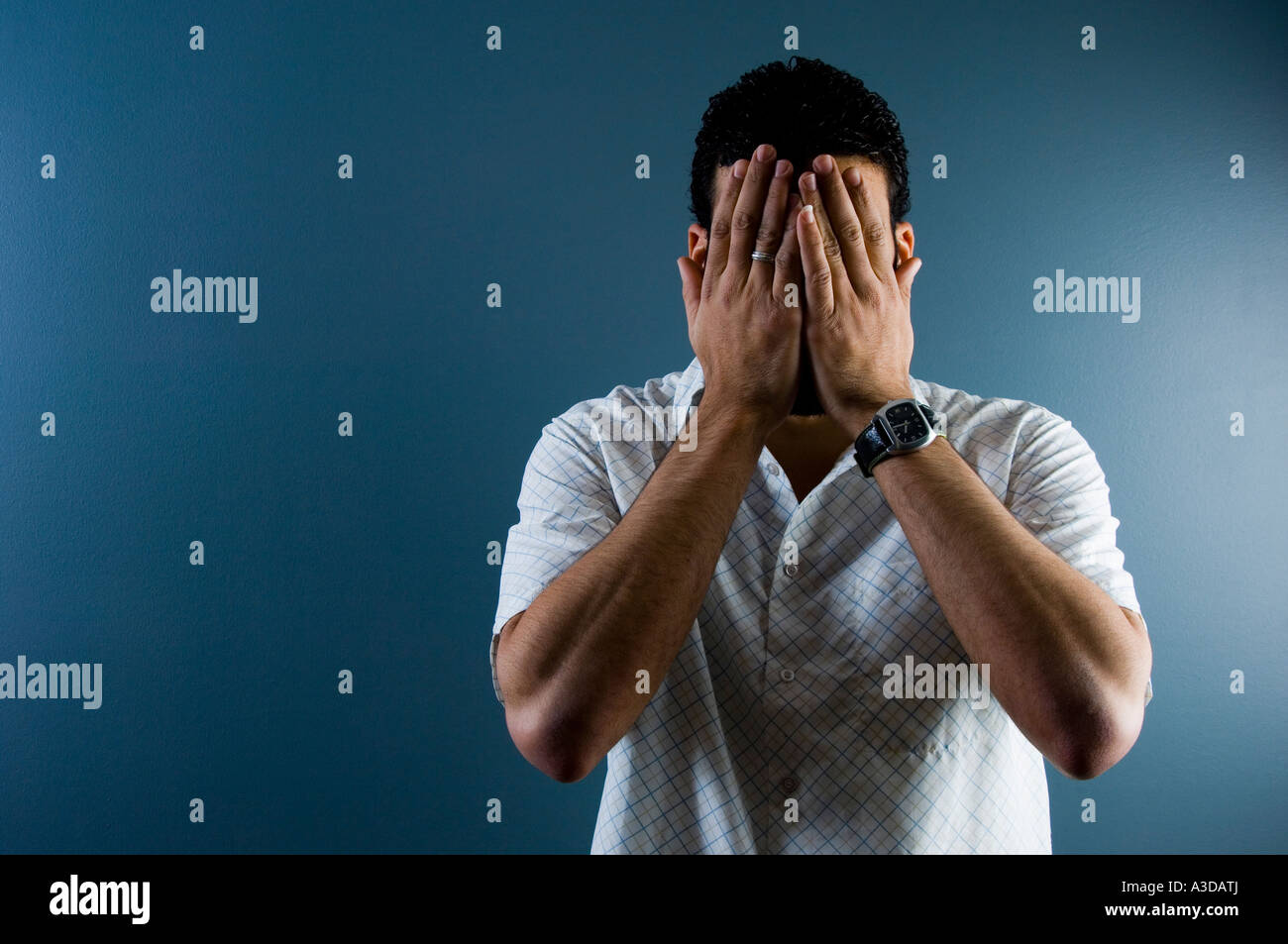 Contemporary image of a man hiding his face indoors Stock Photo - Alamy