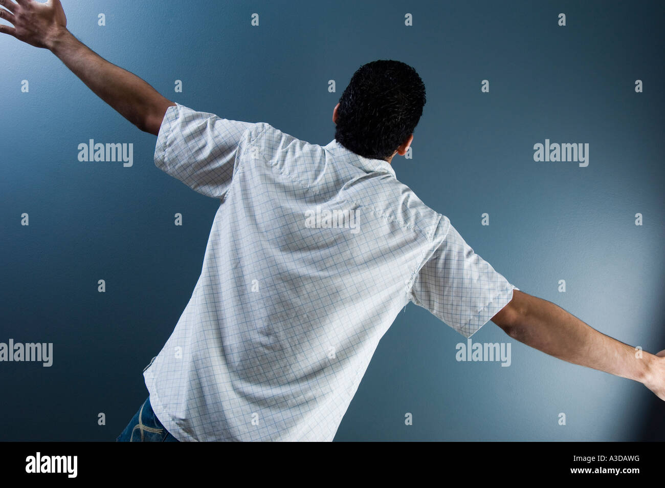Rear view of a man with open arms indoors Stock Photo - Alamy