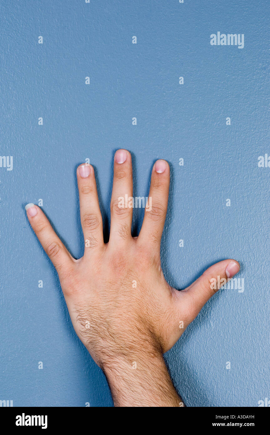 Adult male's hand against the wall Stock Photo - Alamy