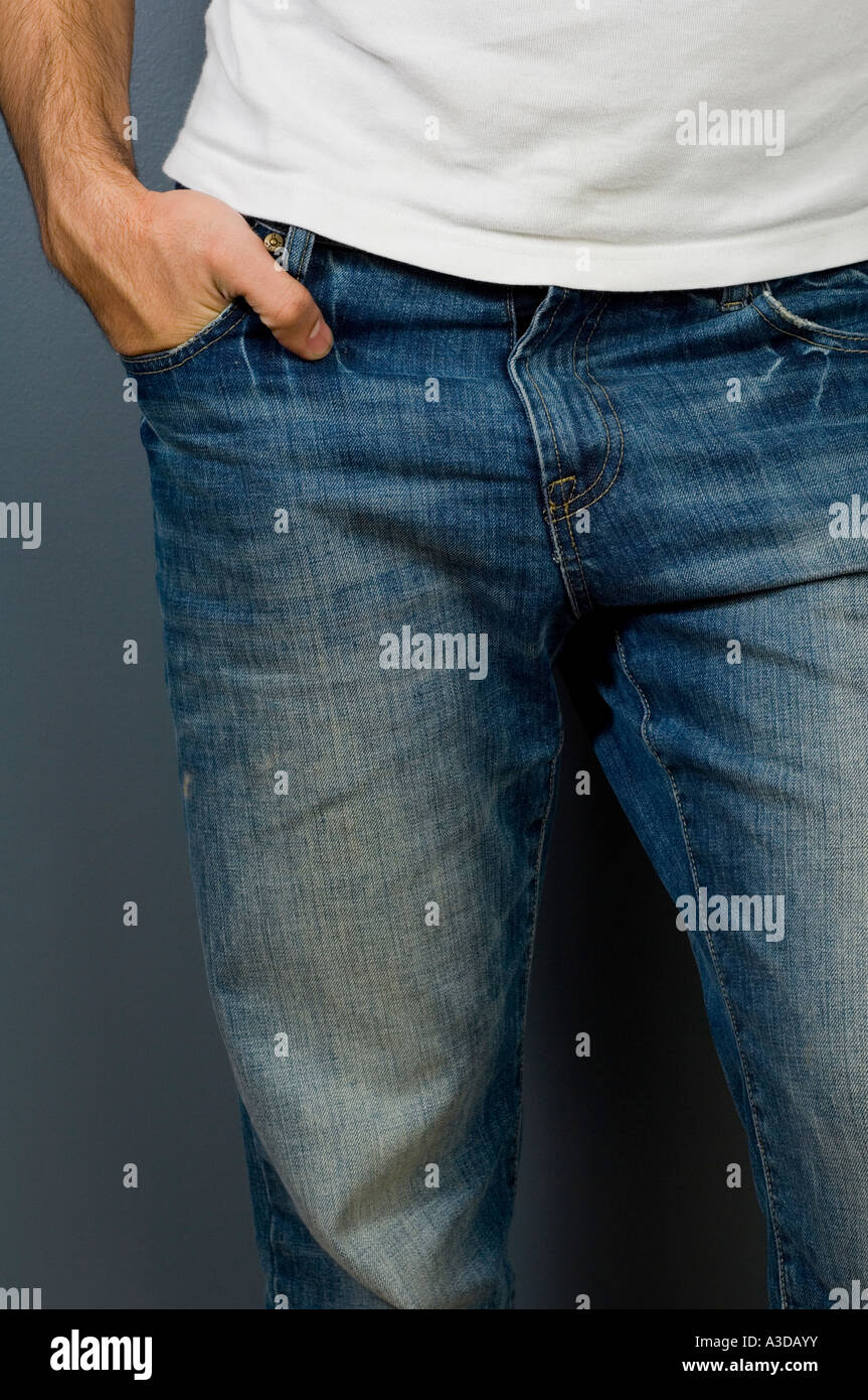Lower part of young man wearing jeans Stock Photo - Alamy