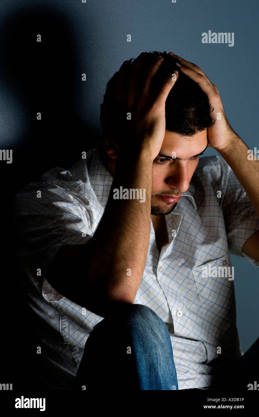 Mournful man sitting head in hands on his bed Stock Photo - Alamy