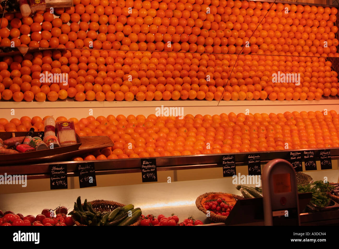 Oranges in line reflecting in mirror at fruit stall Munich Muenchen ...