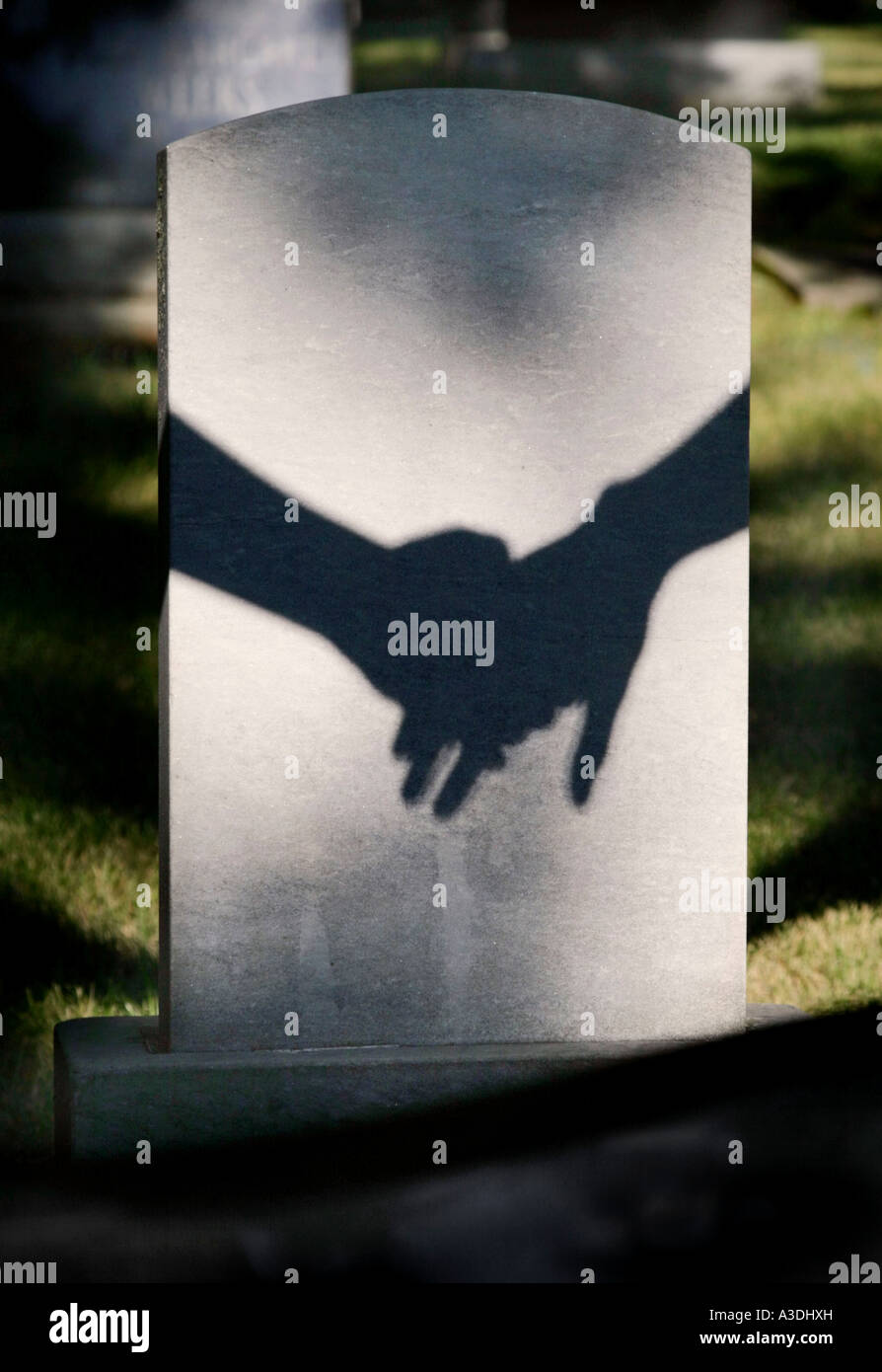 Shadow on tombstone of two clasped hands Stock Photo - Alamy