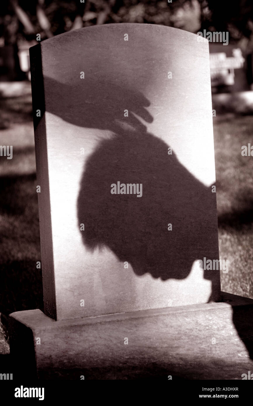 Shadow of hand over head of grieving man at grave site Stock Photo - Alamy