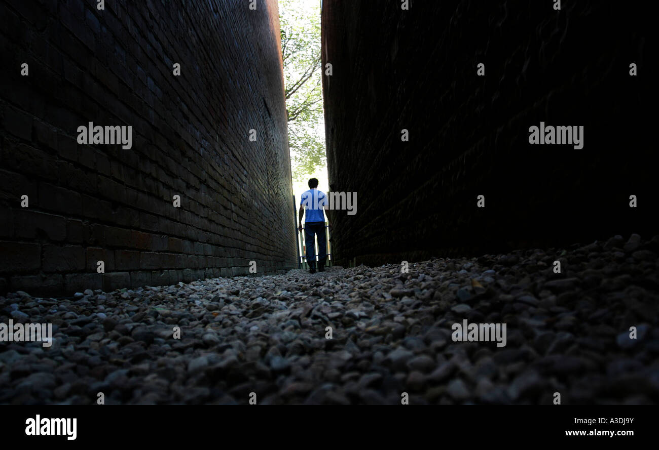Man walking between buildings Stock Photo - Alamy