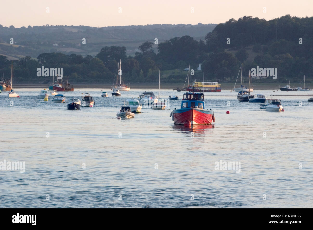 Red Fishing Boat and other moored craft pointing in one direction ...