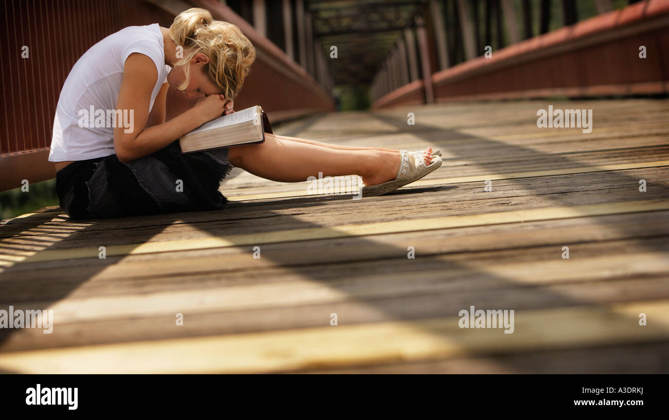 Woman praying on a bridge Stock Photo - Alamy
