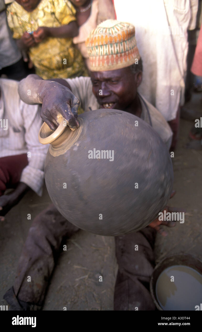 Nigerian male potter spinning a pot using his hands in a village ...