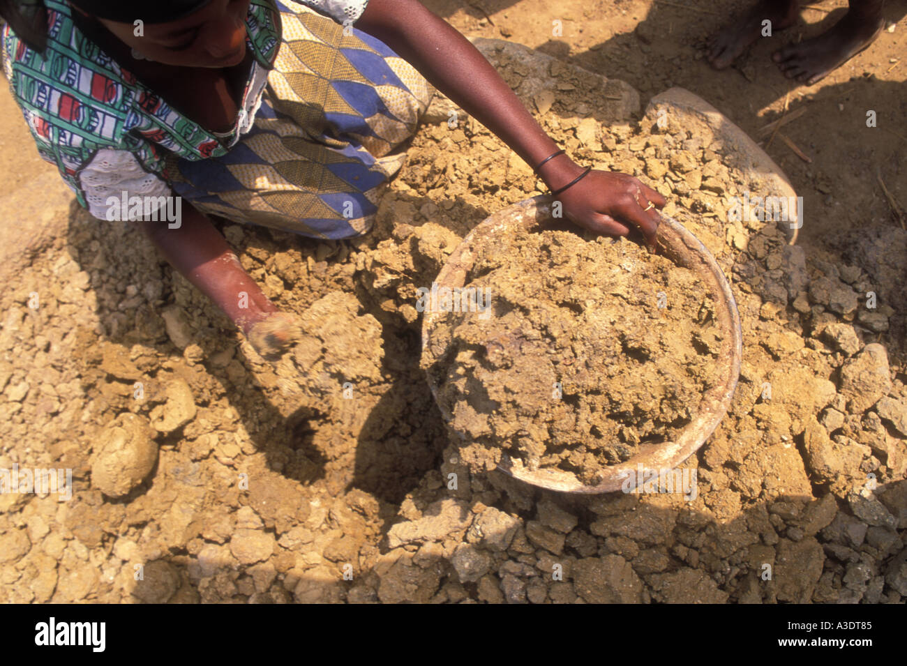 Female nigerian potter collecting dry clay Stock Photo - Alamy
