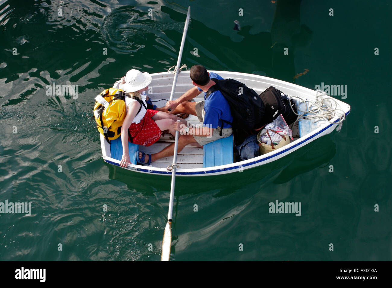 Man rowing small dingy with woman passenger seen from above, Fiji Stock ...