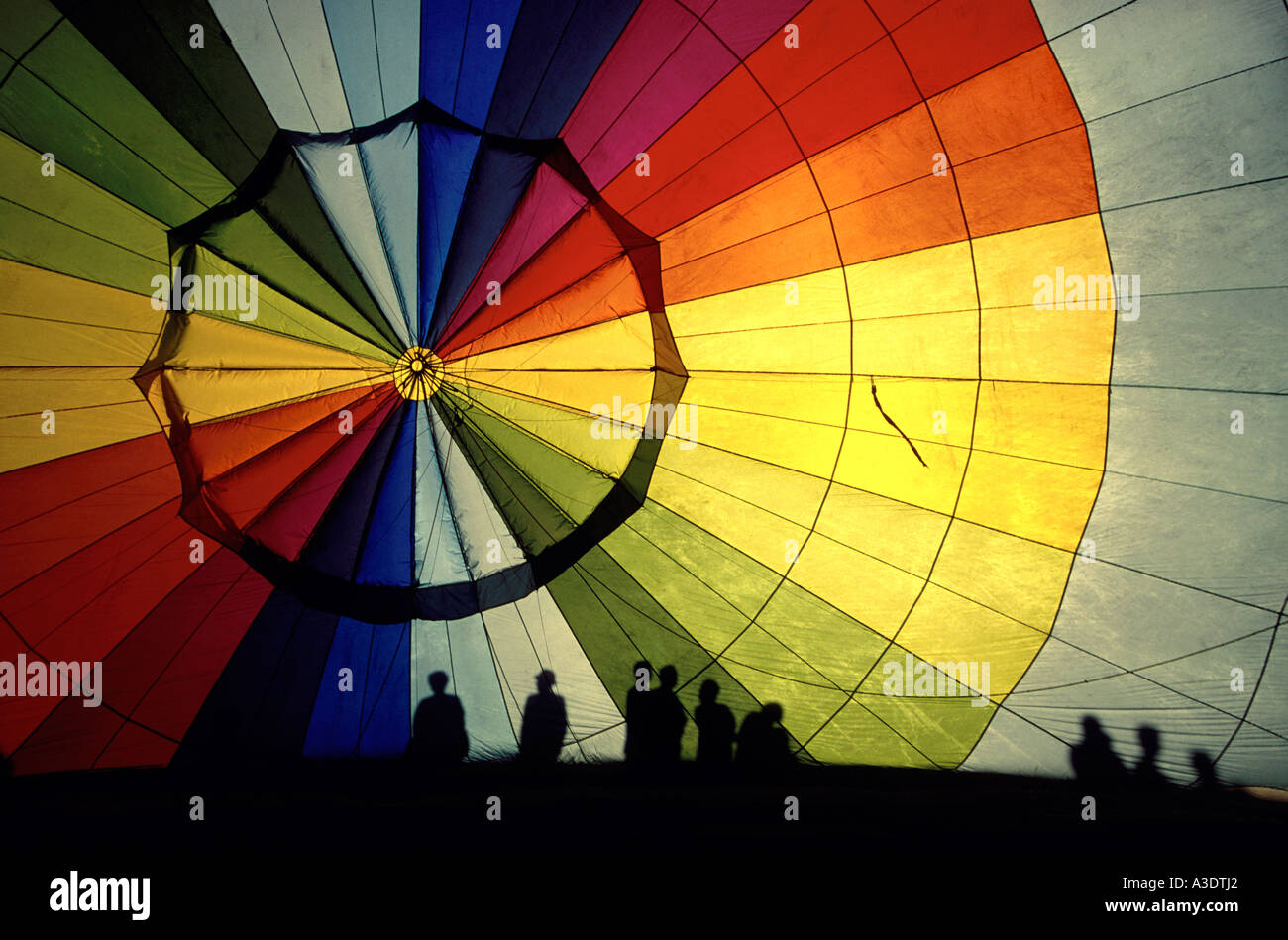 Inside a hot-air balloon during inflation on ground, shadows of people ...