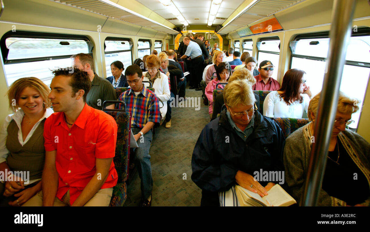People sitting on commuter train, ticket collector in background, New ...