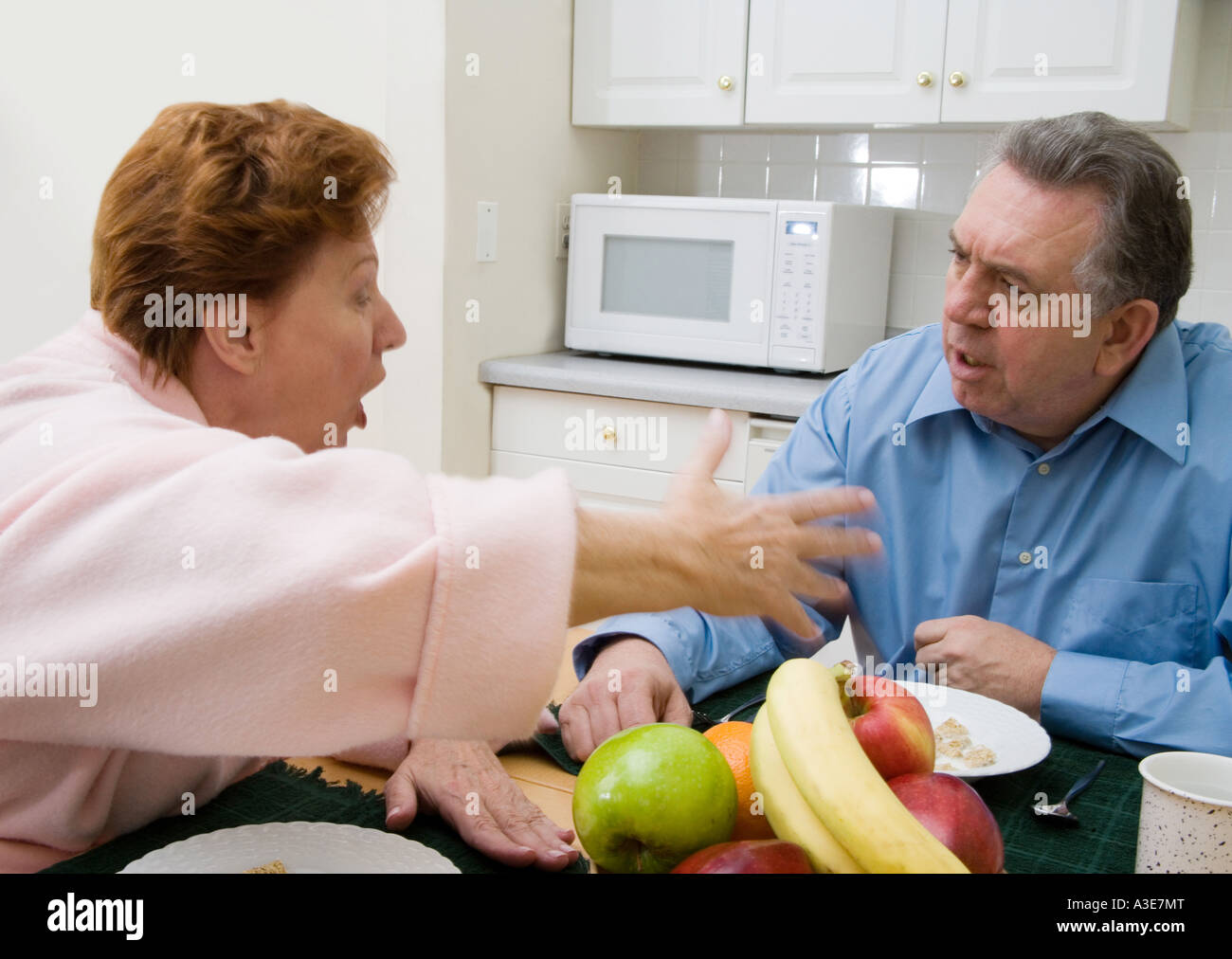 Couple arguing while eating breakfast in their kitchen Stock Photo - Alamy