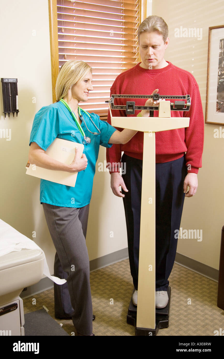Patient on scale being weighed during a physical exam Stock Photo - Alamy