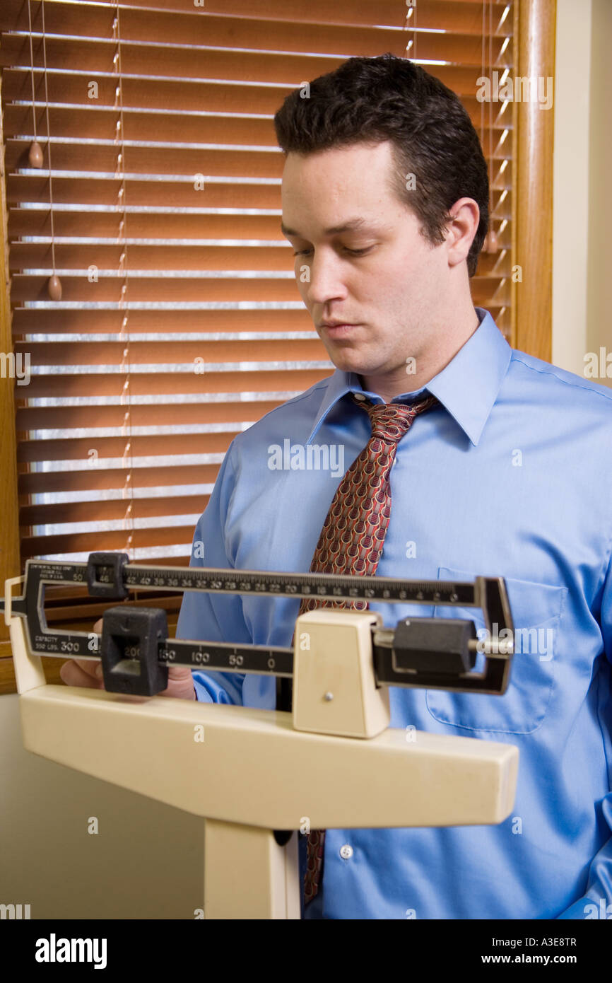 Patient on scale being weighed during a physical exam Stock Photo - Alamy