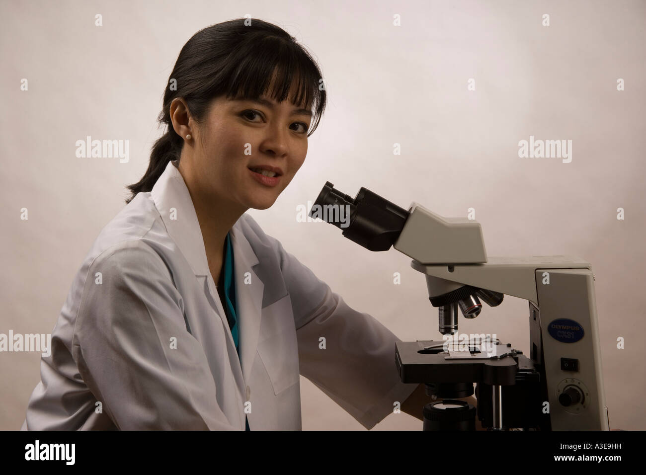 Asian researcher poses with her microscope Stock Photo - Alamy