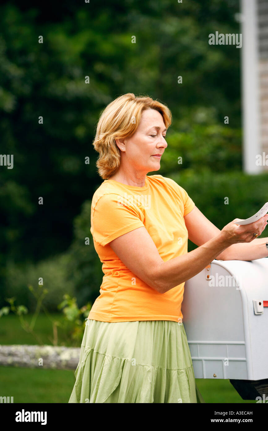 Side profile of a mature woman standing by a mailbox Stock Photo - Alamy
