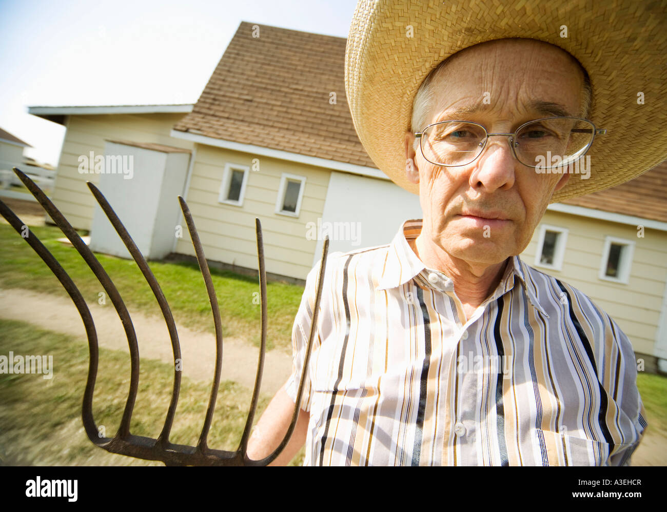 Farmer holding a pitchfork Stock Photo - Alamy