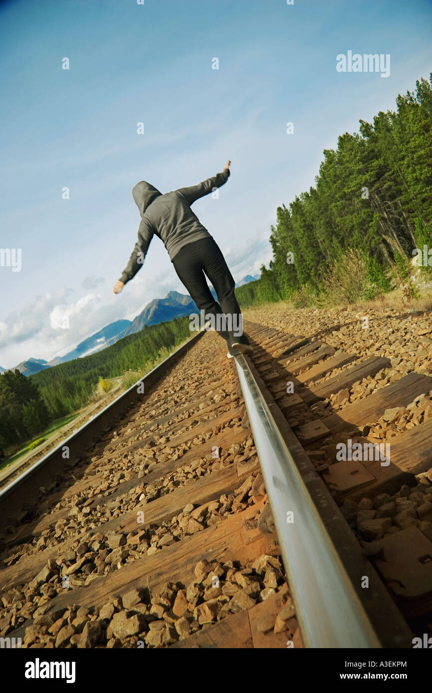 Woman walking on railroad track Stock Photo - Alamy
