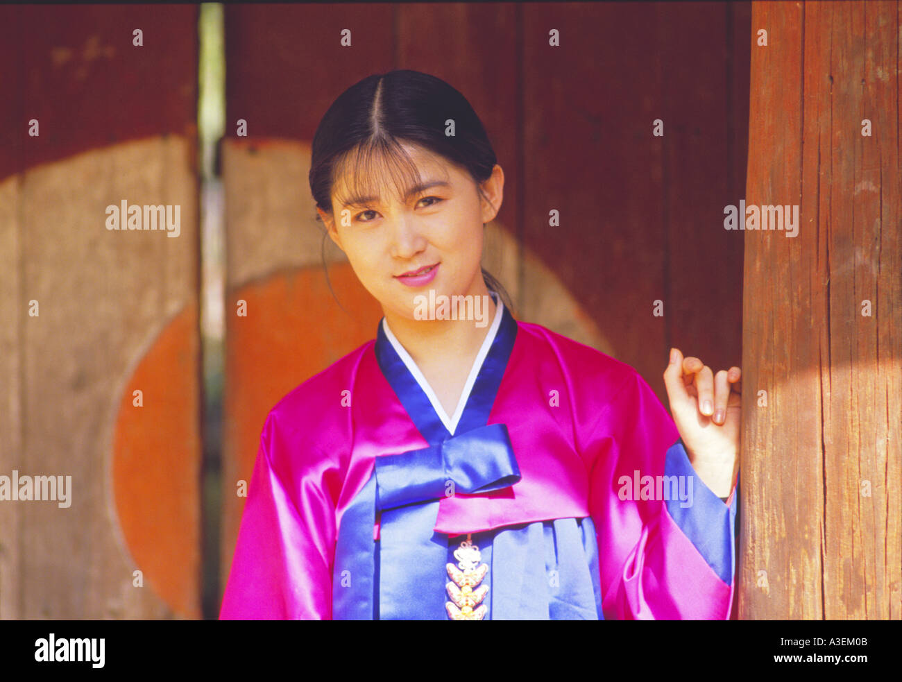 A young korean lady with traditional costume posed next to a Korean ...