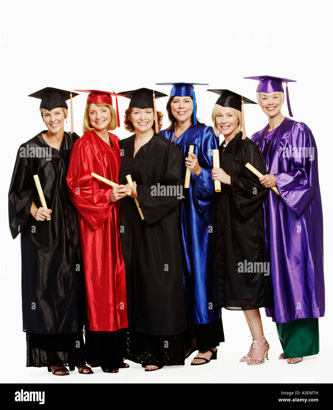 Portrait of a group of mature women wearing graduation gowns and ...