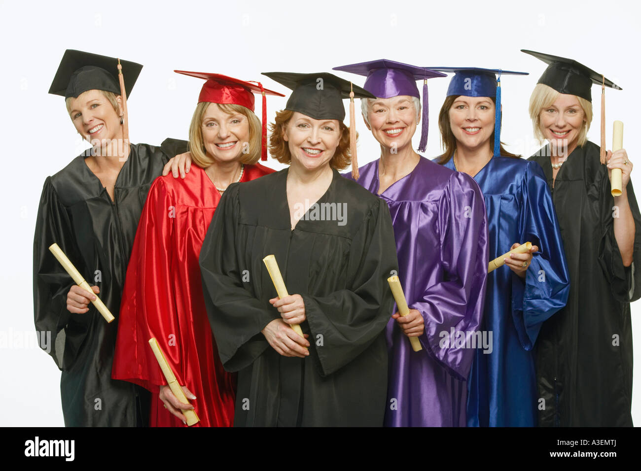 Portrait of a group of mature women wearing graduation gowns and ...