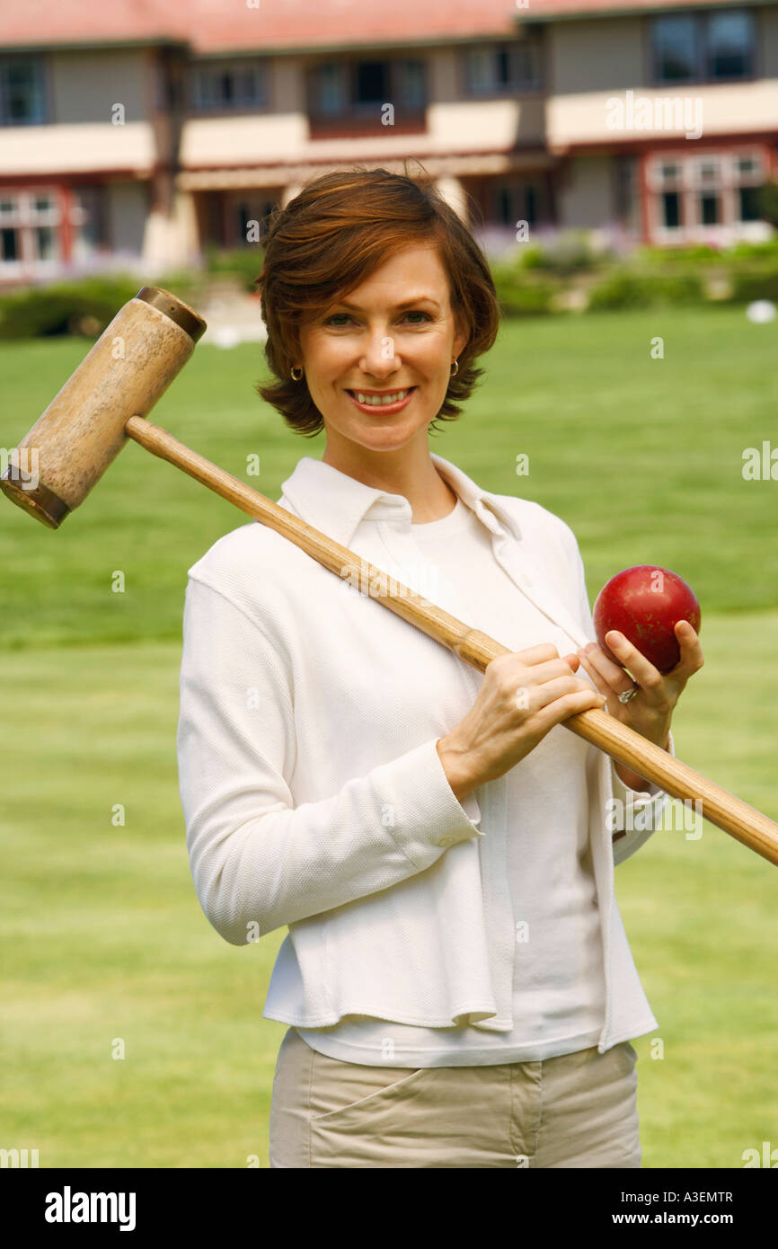 Portrait of a mid adult woman holding a croquet mallet and a ball Stock ...