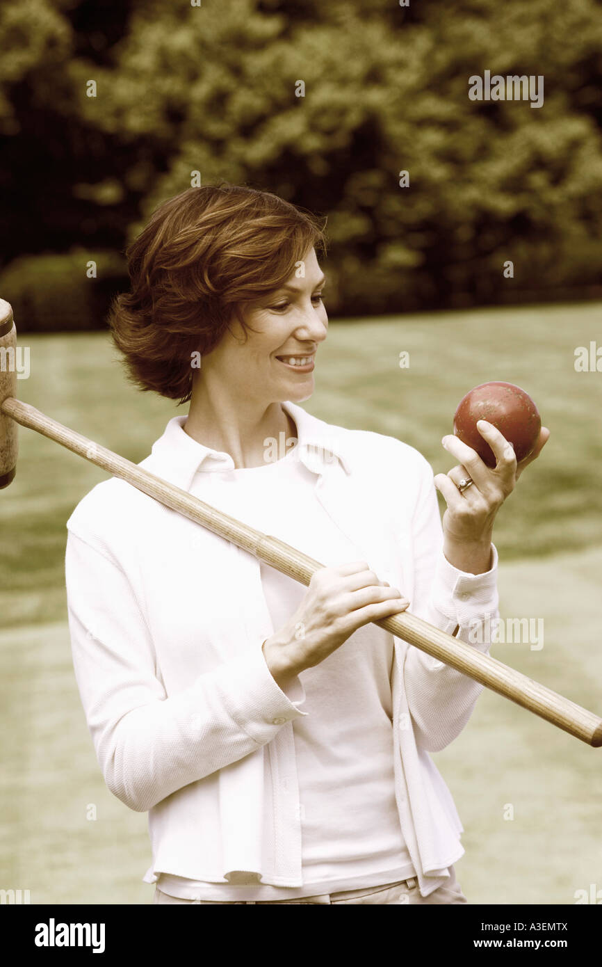 Close-up of a mid adult woman holding a croquet mallet and a ball Stock ...