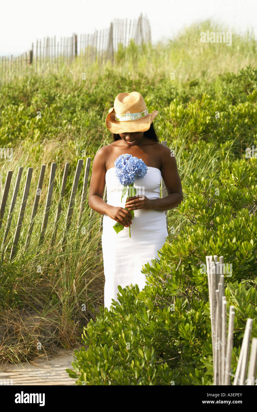 Mid adult woman standing and holding a flower Stock Photo - Alamy