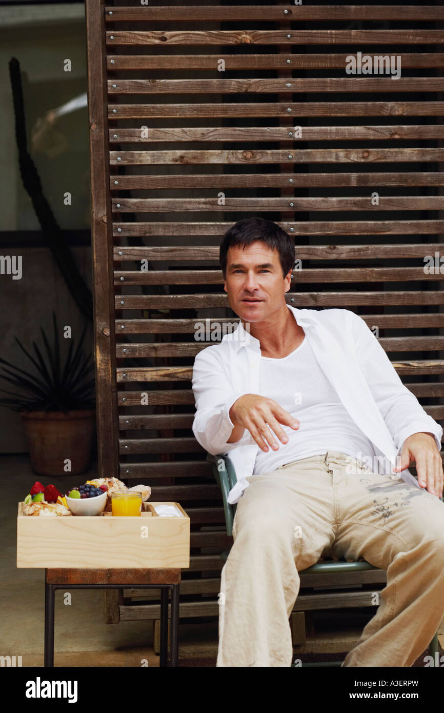 Portrait of a mature man reclining on a chair Stock Photo - Alamy