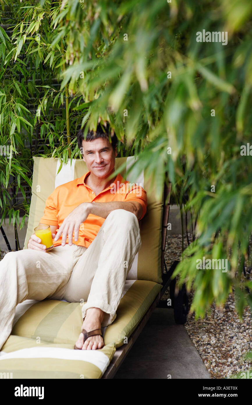 Portrait of a mature man reclining on a lounge chair Stock Photo - Alamy