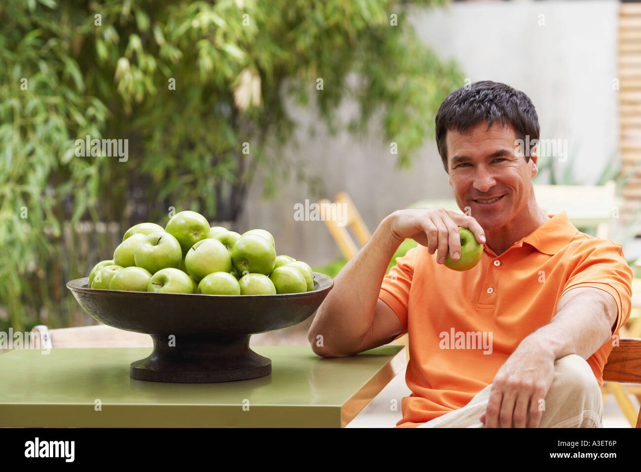 Portrait of a mature man holding a granny smith apple and smiling Stock ...