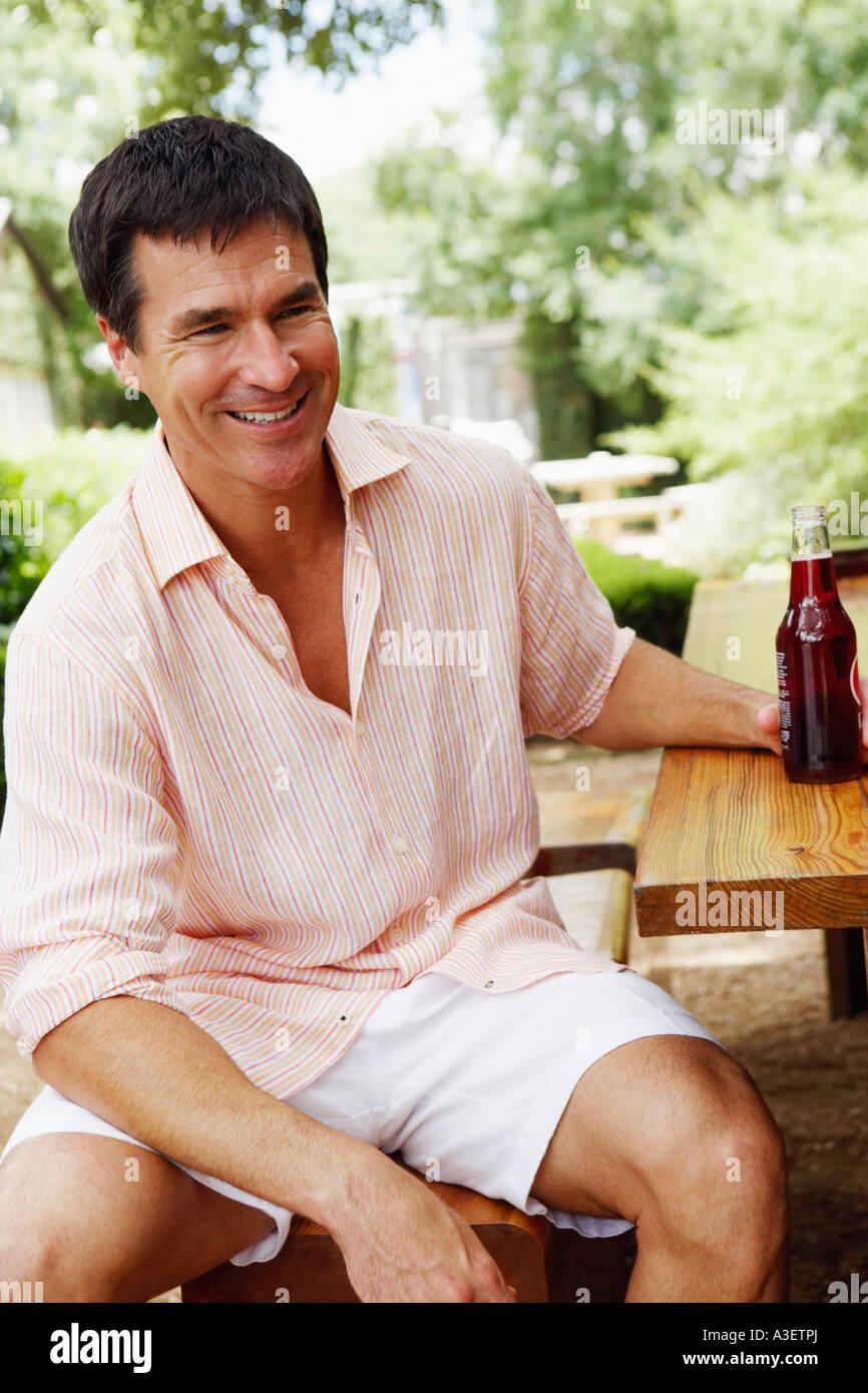 Close-up of a mature man sitting on a stool and smiling Stock Photo - Alamy