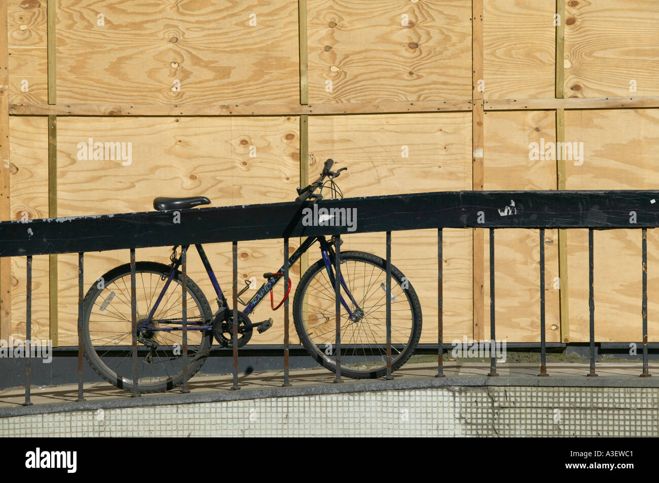 bicycle chained to fence near building site Stock Photo - Alamy