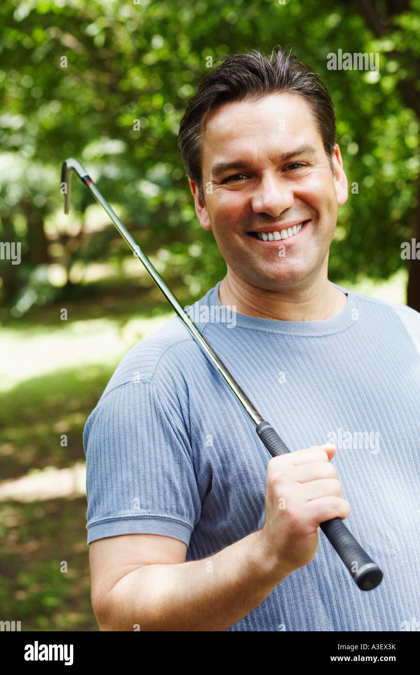Close-up of a mature man holding a golf club and smiling Stock Photo ...
