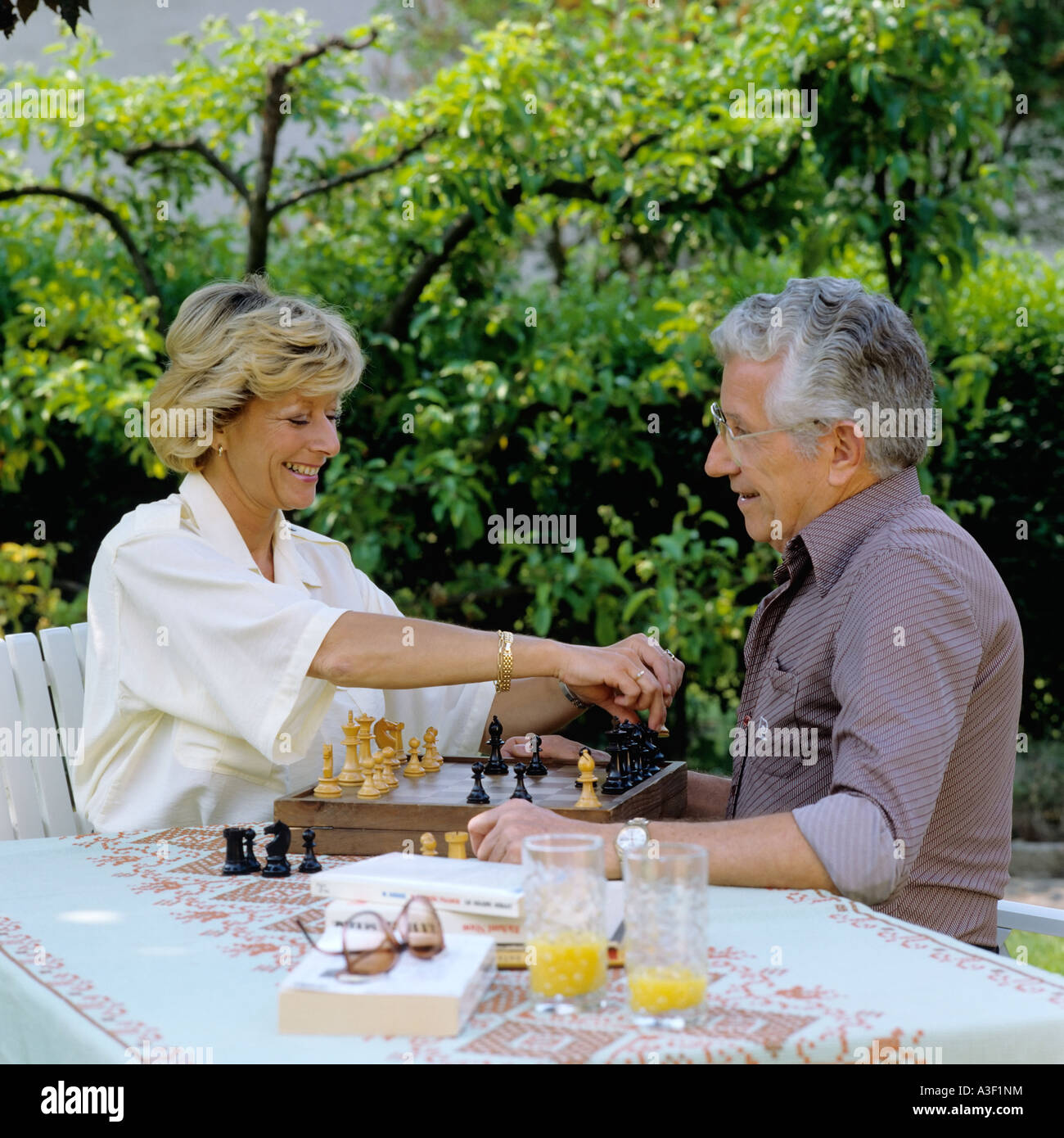 MR MATURE COUPLE PLAYING CHESS IN GARDEN Stock Photo - Alamy